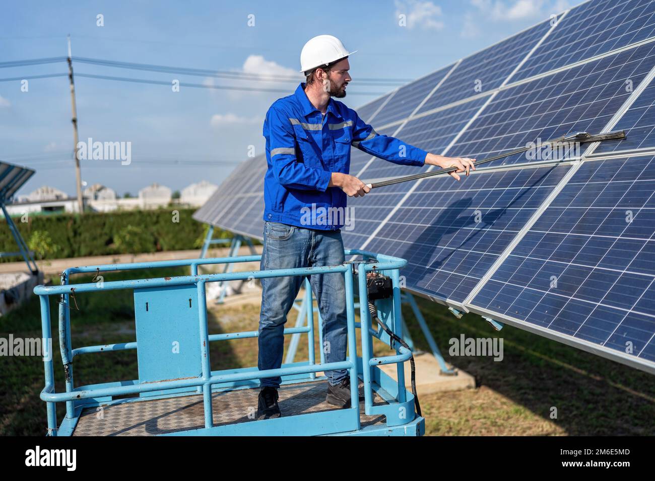 Service engineer use a mop cleaning solar panel for good performance ...