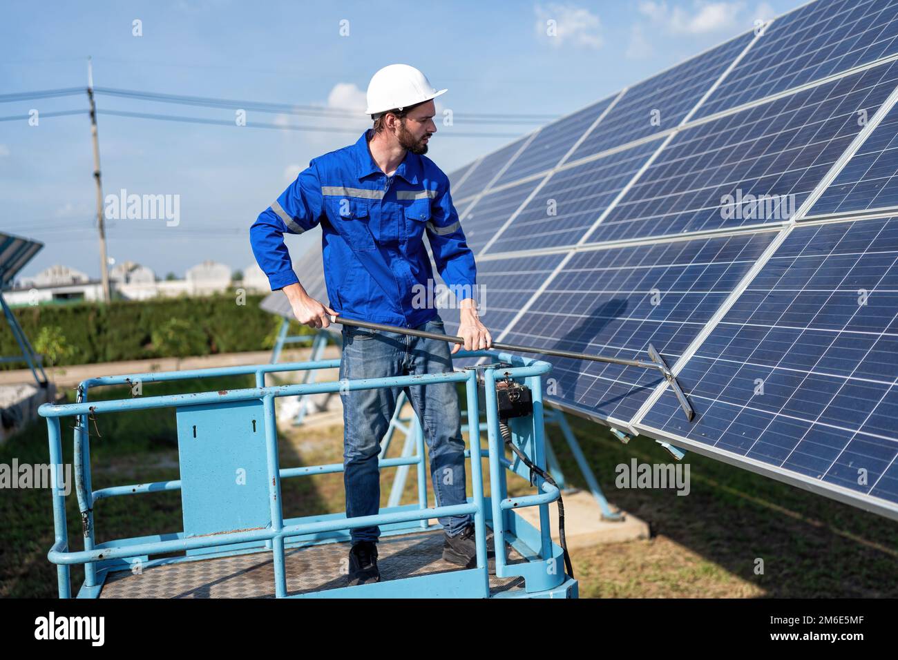 Service engineer use a mop cleaning solar panel for good performance ...