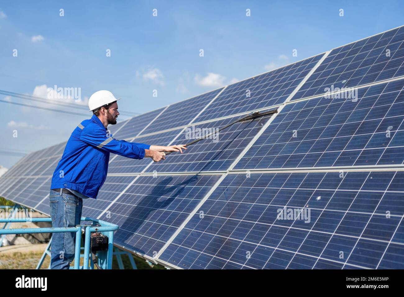 Service engineer use a mop cleaning solar panel for good performance ...