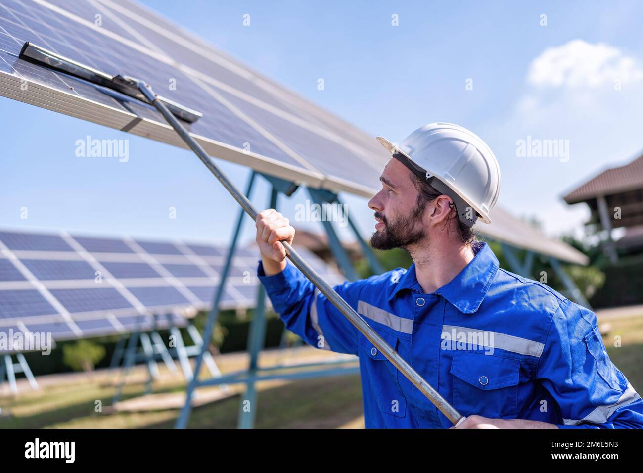 Service engineer use a mop cleaning solar panel for good performance ...