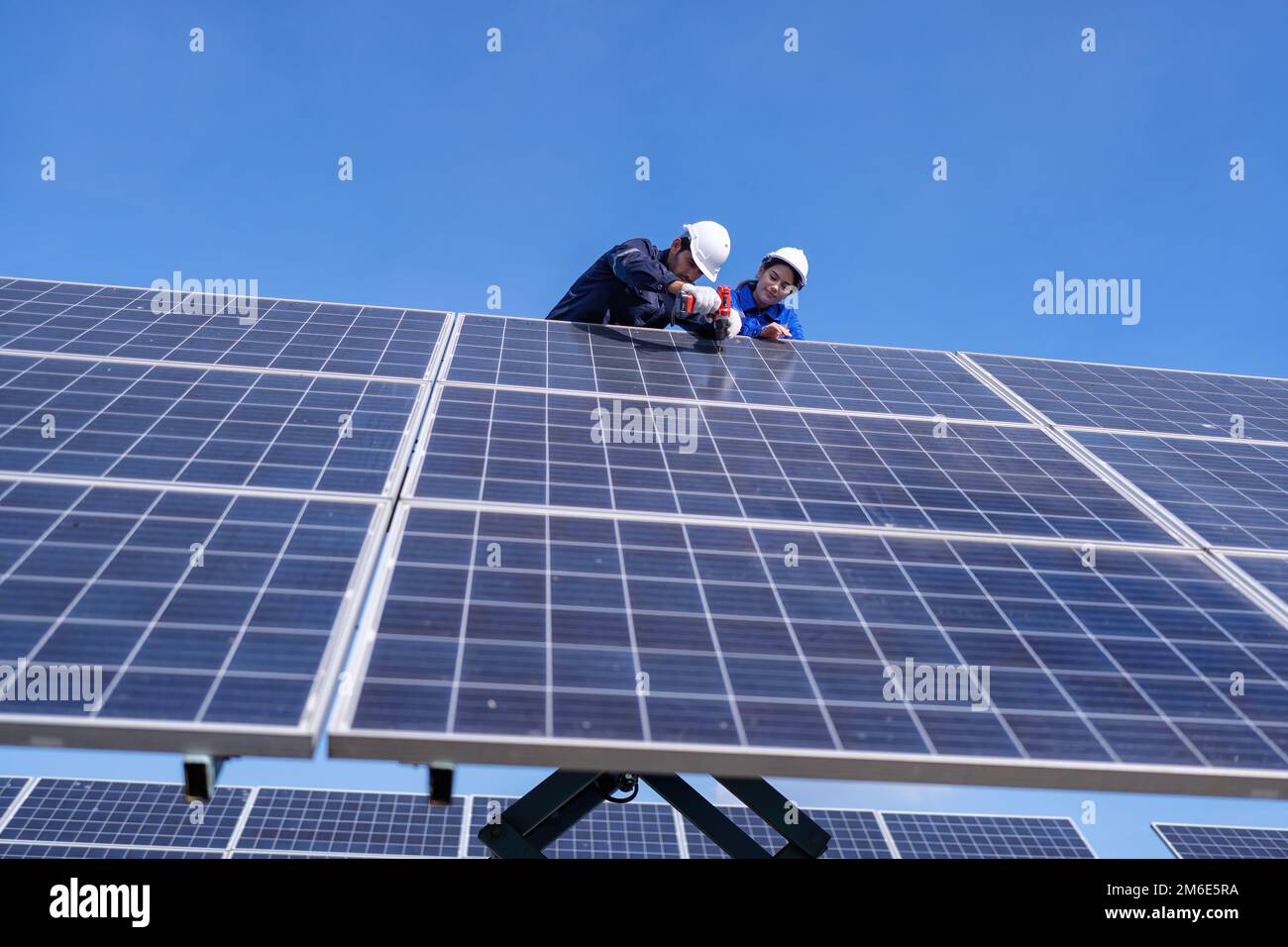 Maintenance engineer at solar farm stand on scissor lift inspection ...