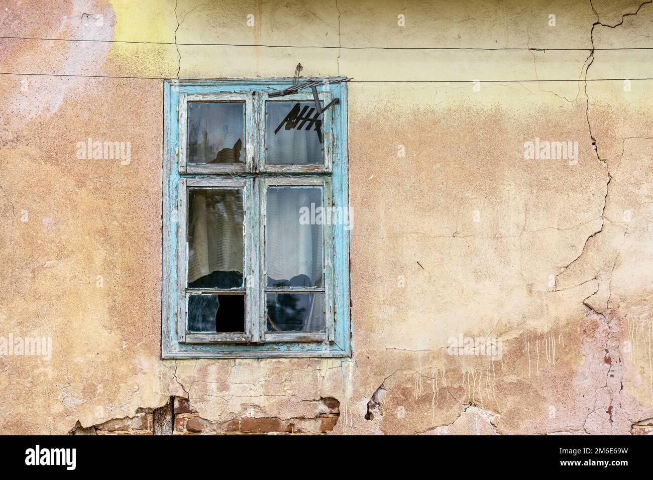 Abandoned ruined house, a window on the wall of an abandoned house ...