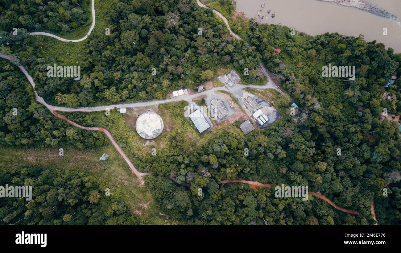 Road through the green rainforest. Aerial top view forest with small ...