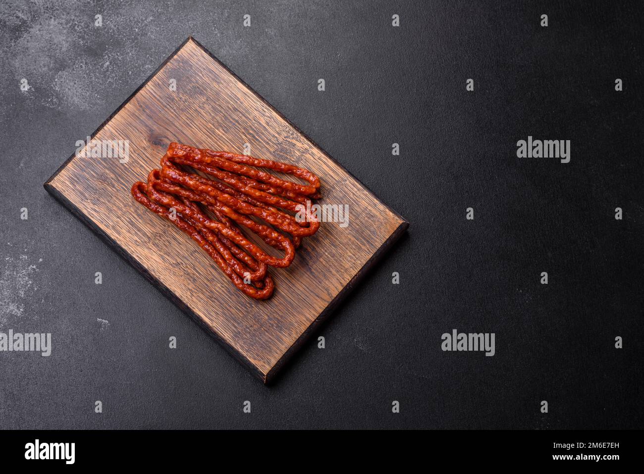 Delicious thin smoked meat sausages with spices and herbs on a dark ...