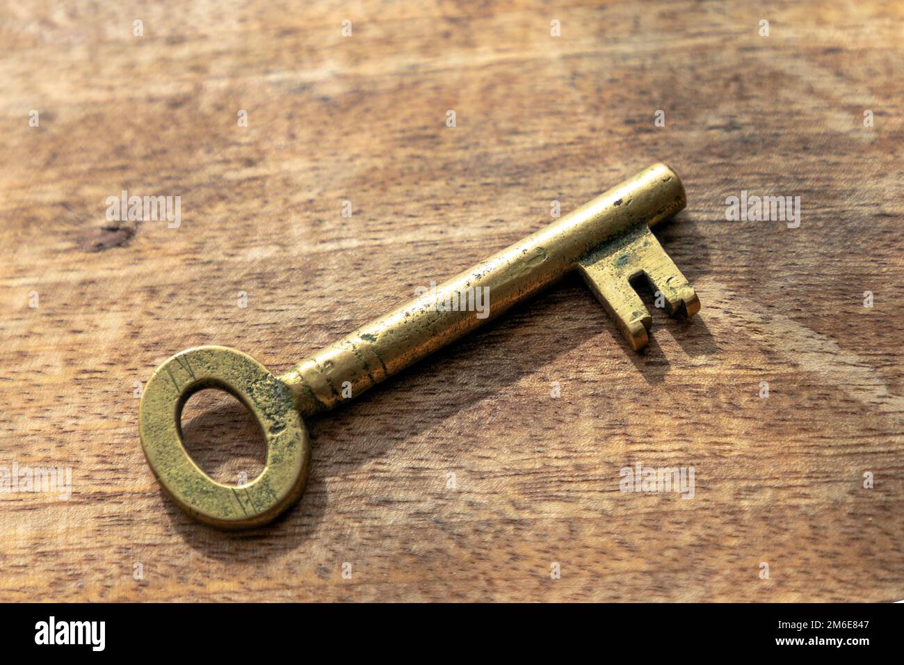 Old brass key on a wooden background Stock Photo - Alamy