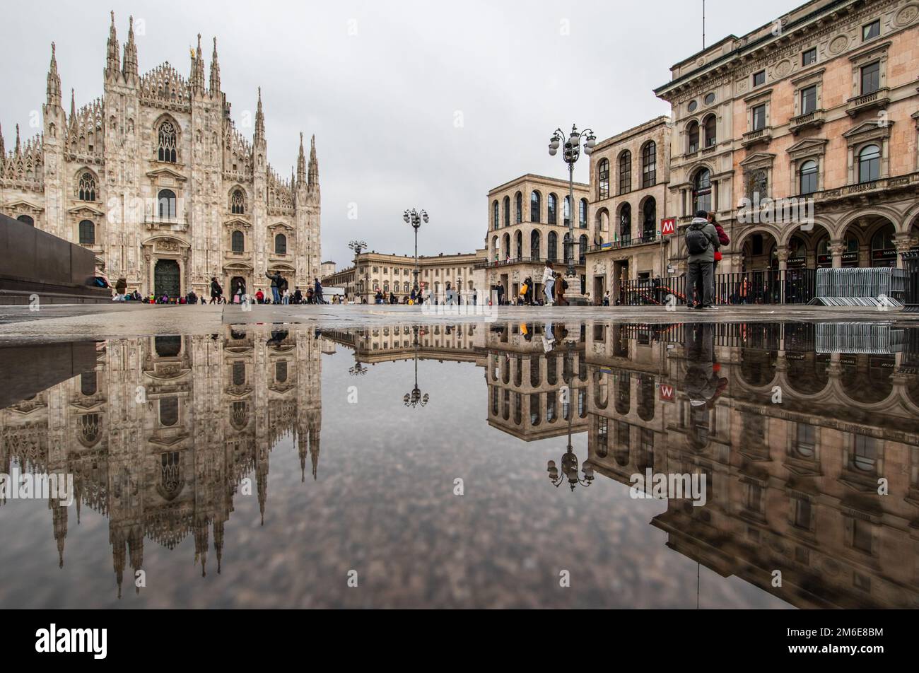 Frequent rainshowers in Milan create waterpools in which Old Town ...