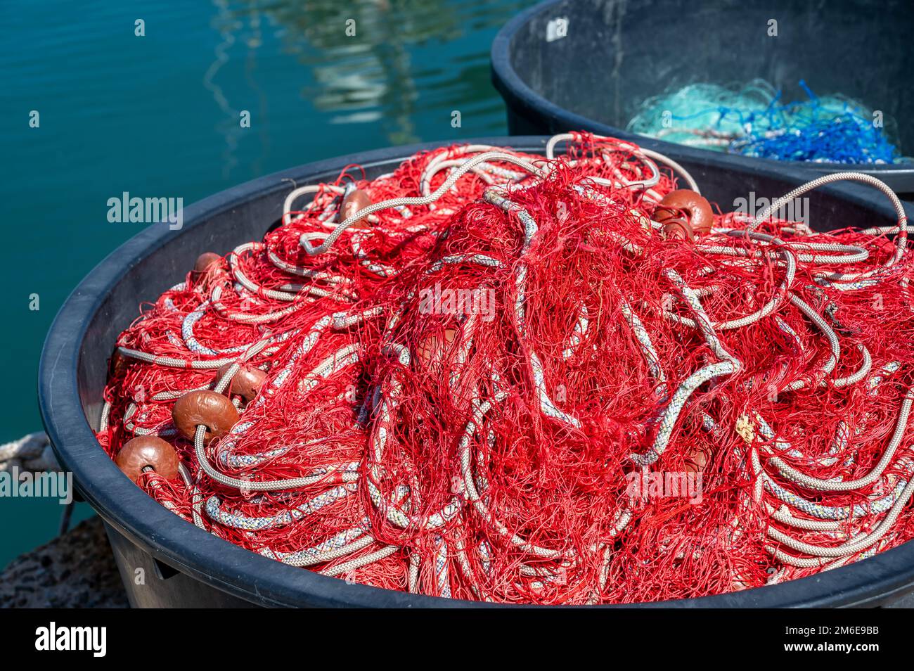 Red fishing net in a vat at the harbor Stock Photo - Alamy