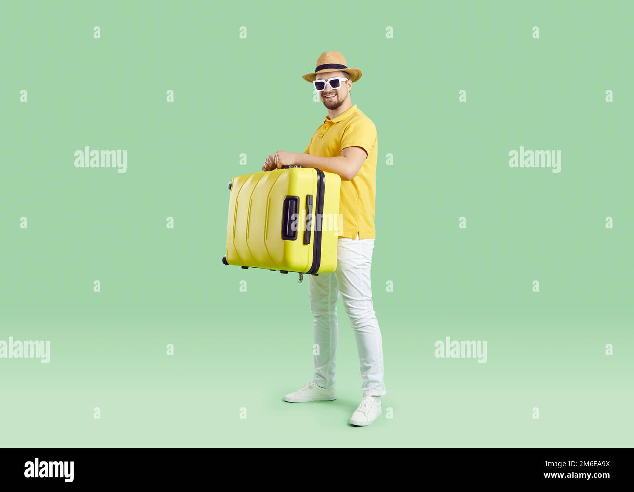 Happy guy traveler with yellow suitcase goes on summer vacation ...