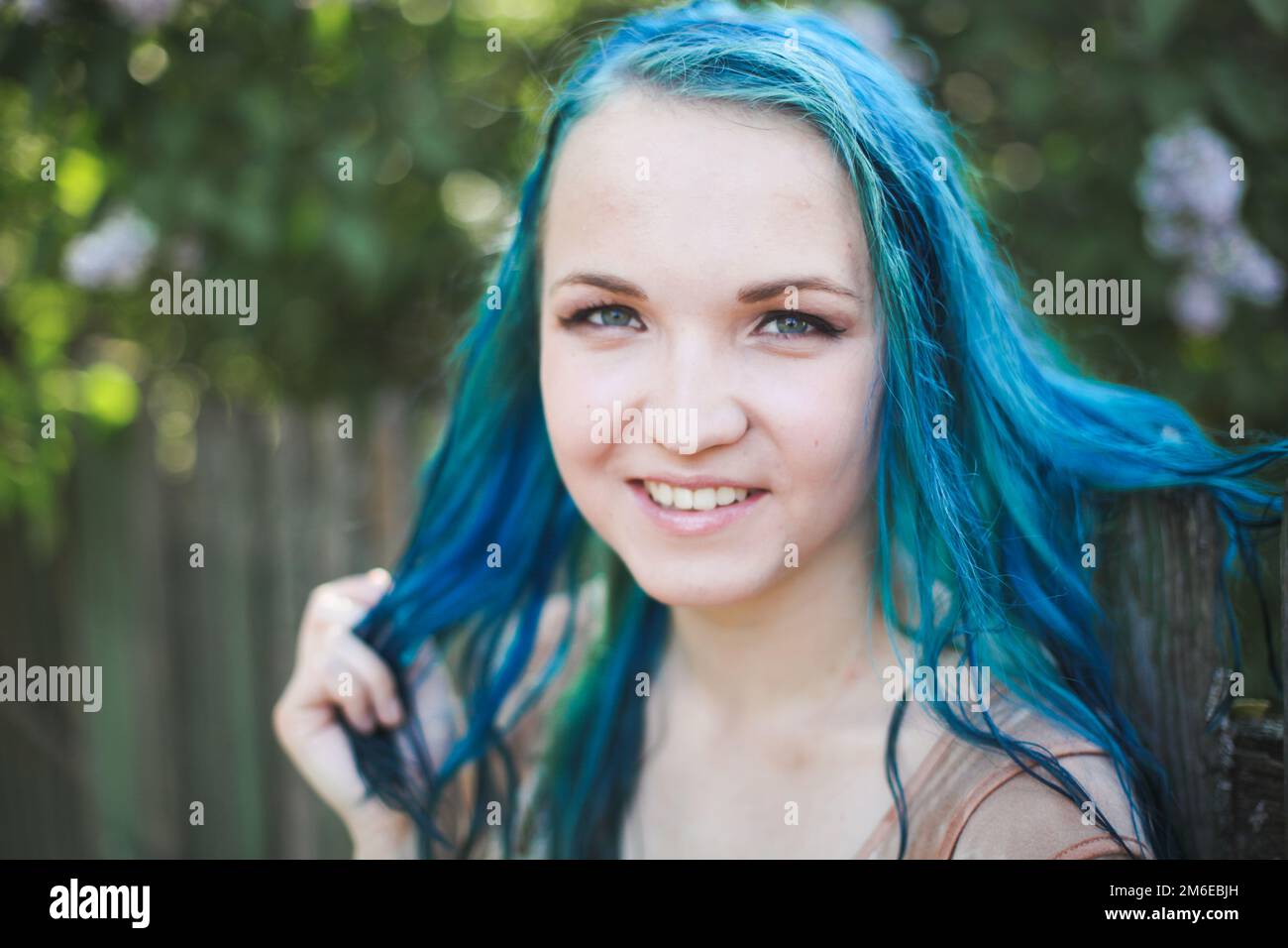 Young dreamy lgbt girl with colored blue hair Stock Photo - Alamy