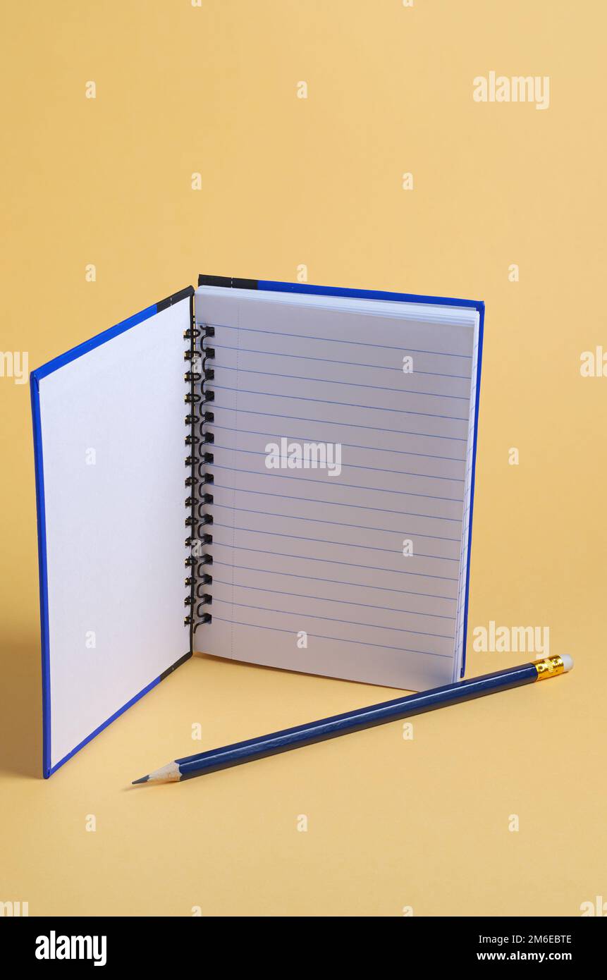 Opened notebook and pencil on yellow background Stock Photo - Alamy