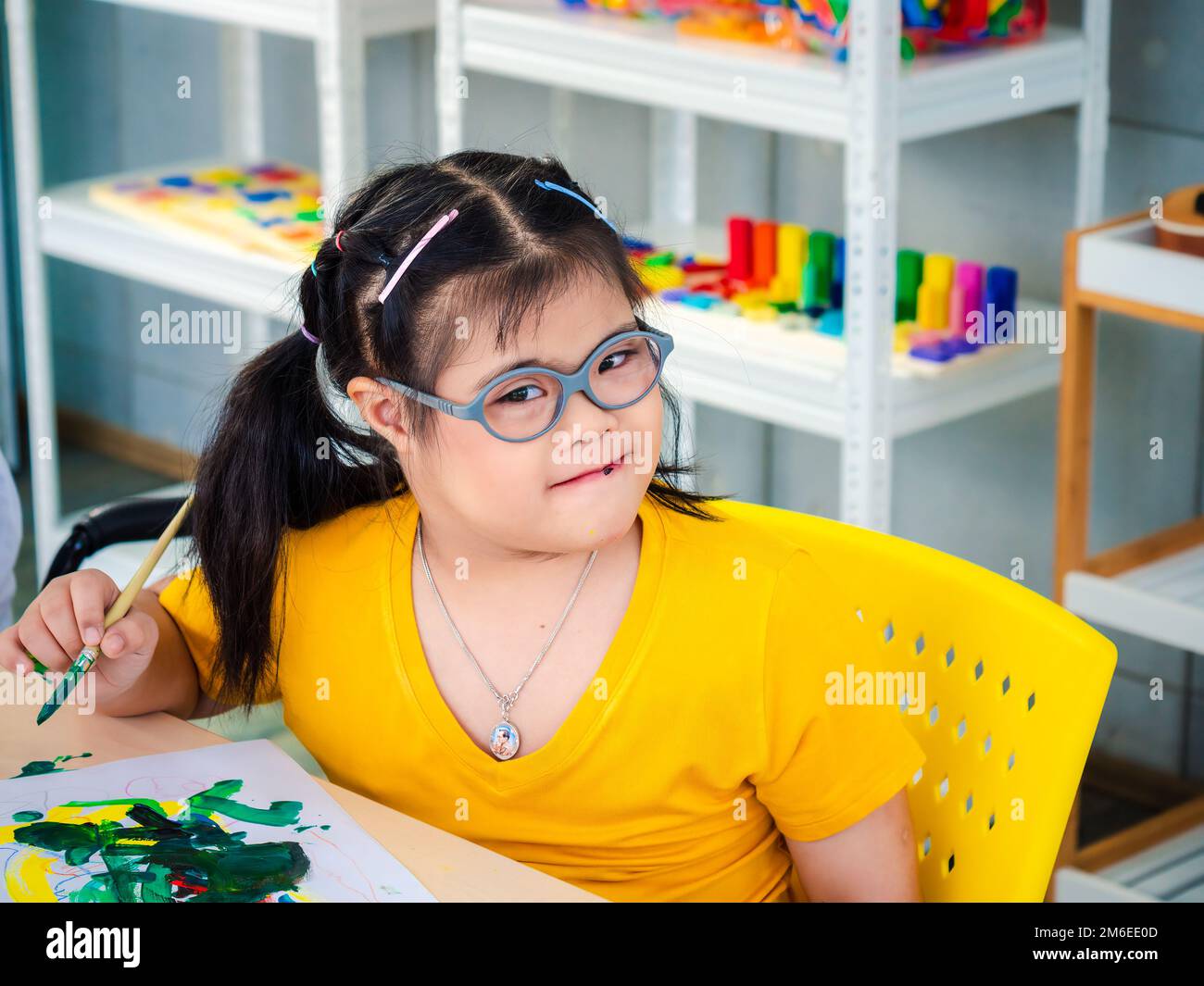 A cheerful group creative arts class for kids and their teacher in the school classroom, happy ...