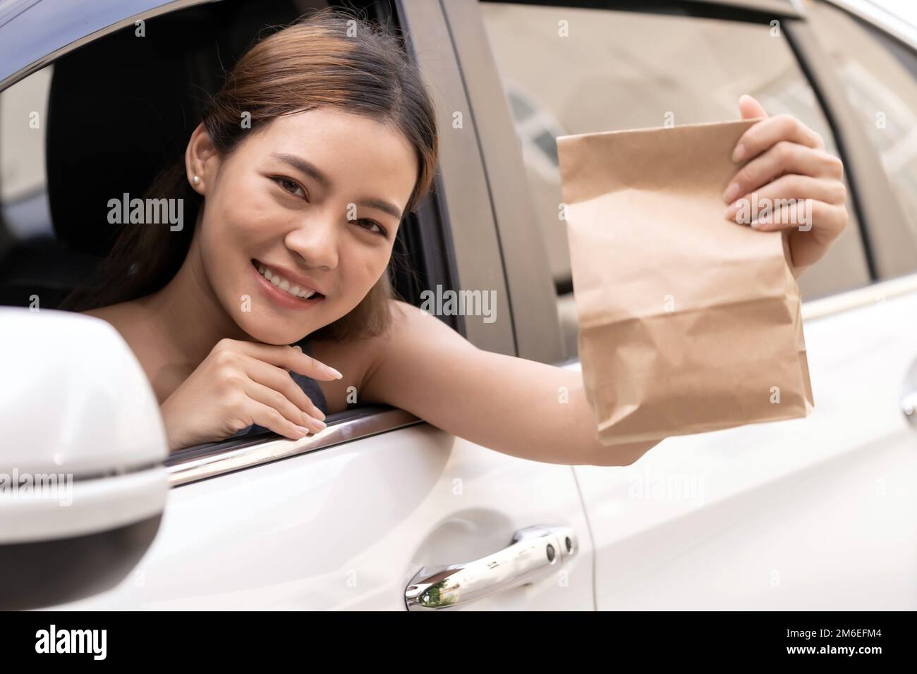 Asian woman holding food bag from drive thru service restaurant Stock ...