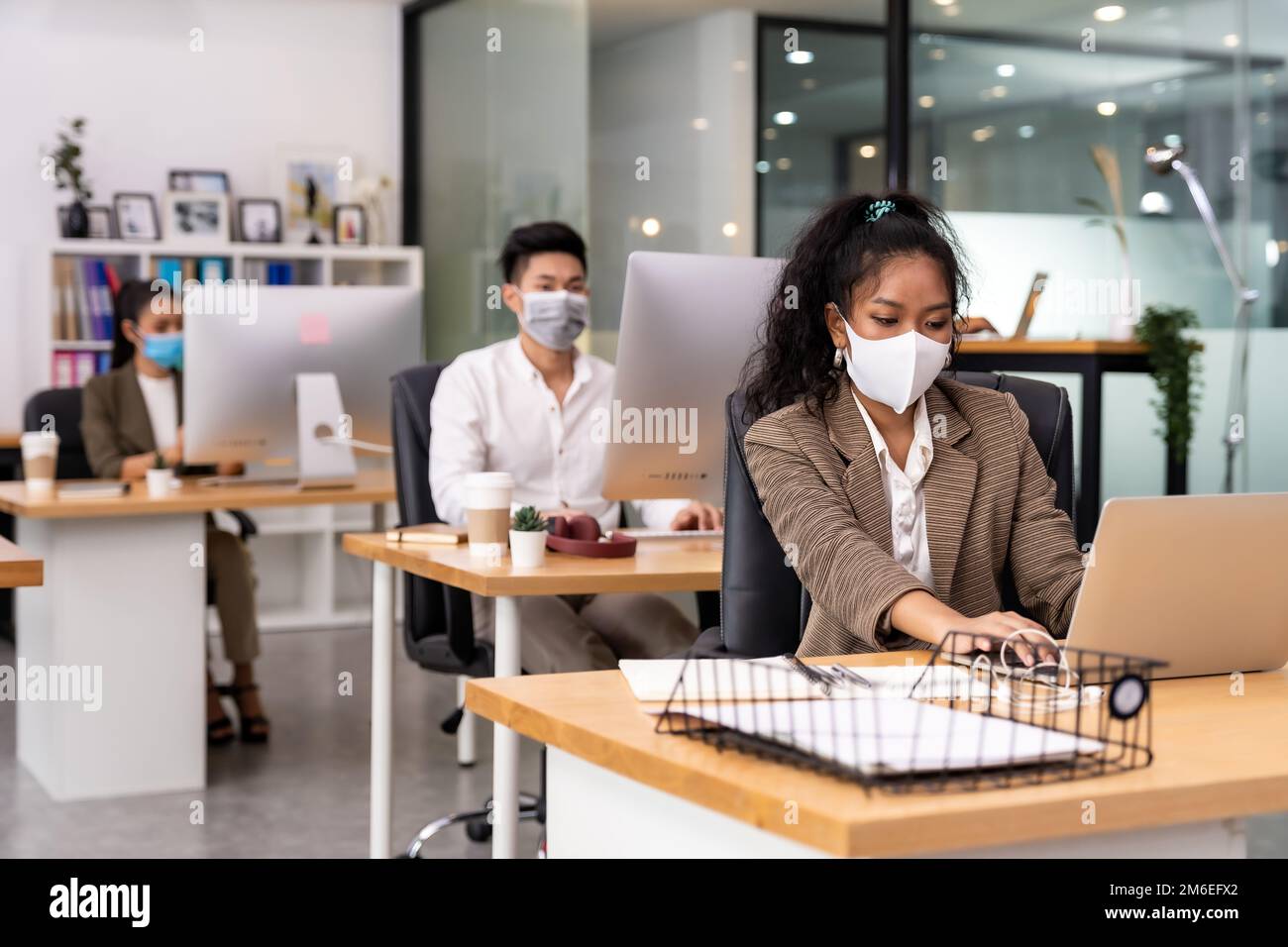 African office worker with asian team in new normal social distance ...
