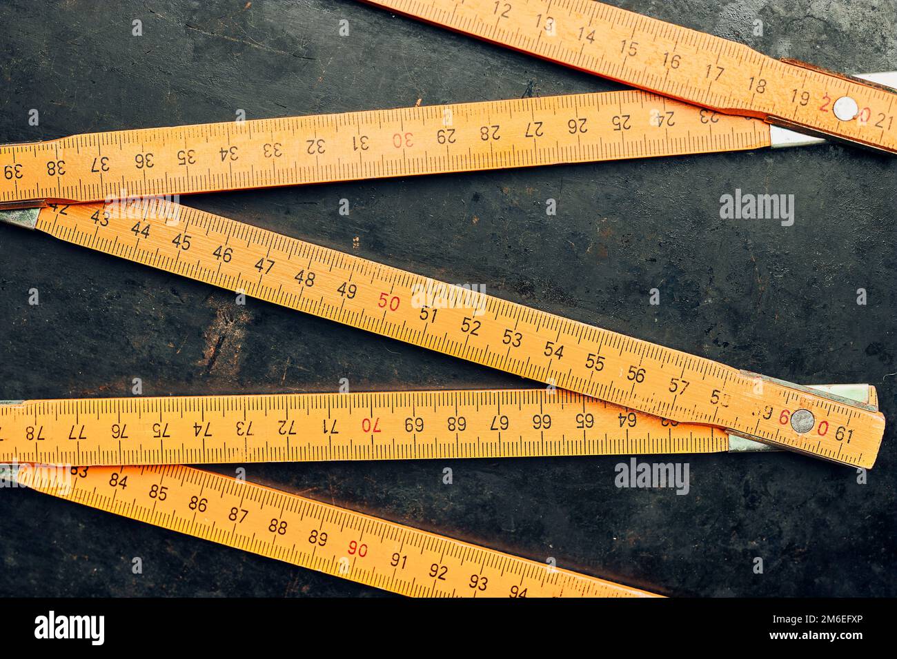 Wooden measure. Old ruler on metal surface. Measuring tool. Technical ...