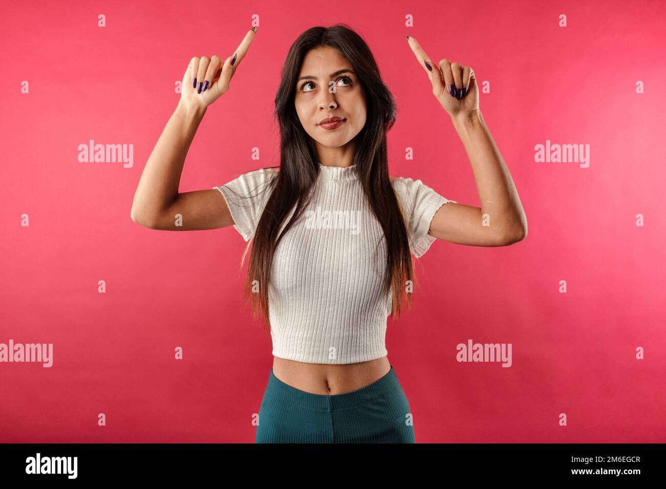 Young beautiful woman wearing ribbed crop isolated over red background ...
