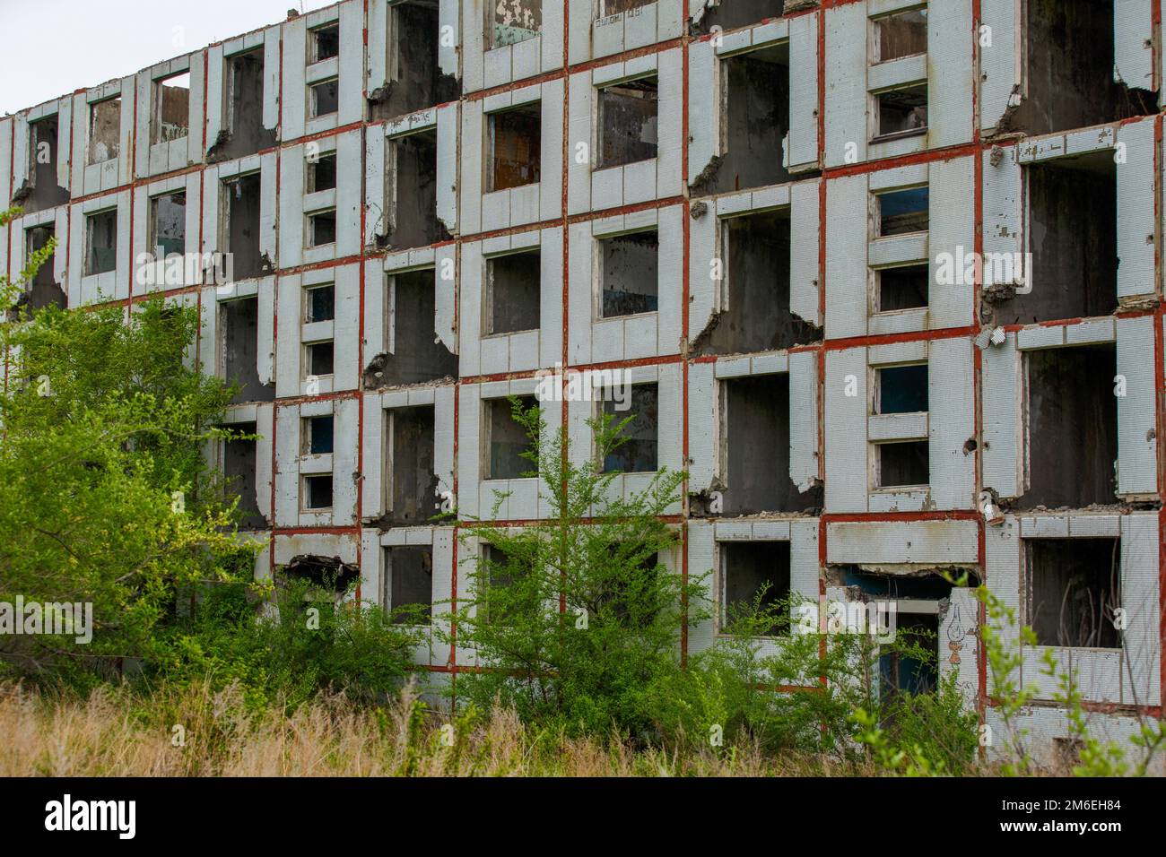 An abandoned multi-storey building stands in the middle of a green ...
