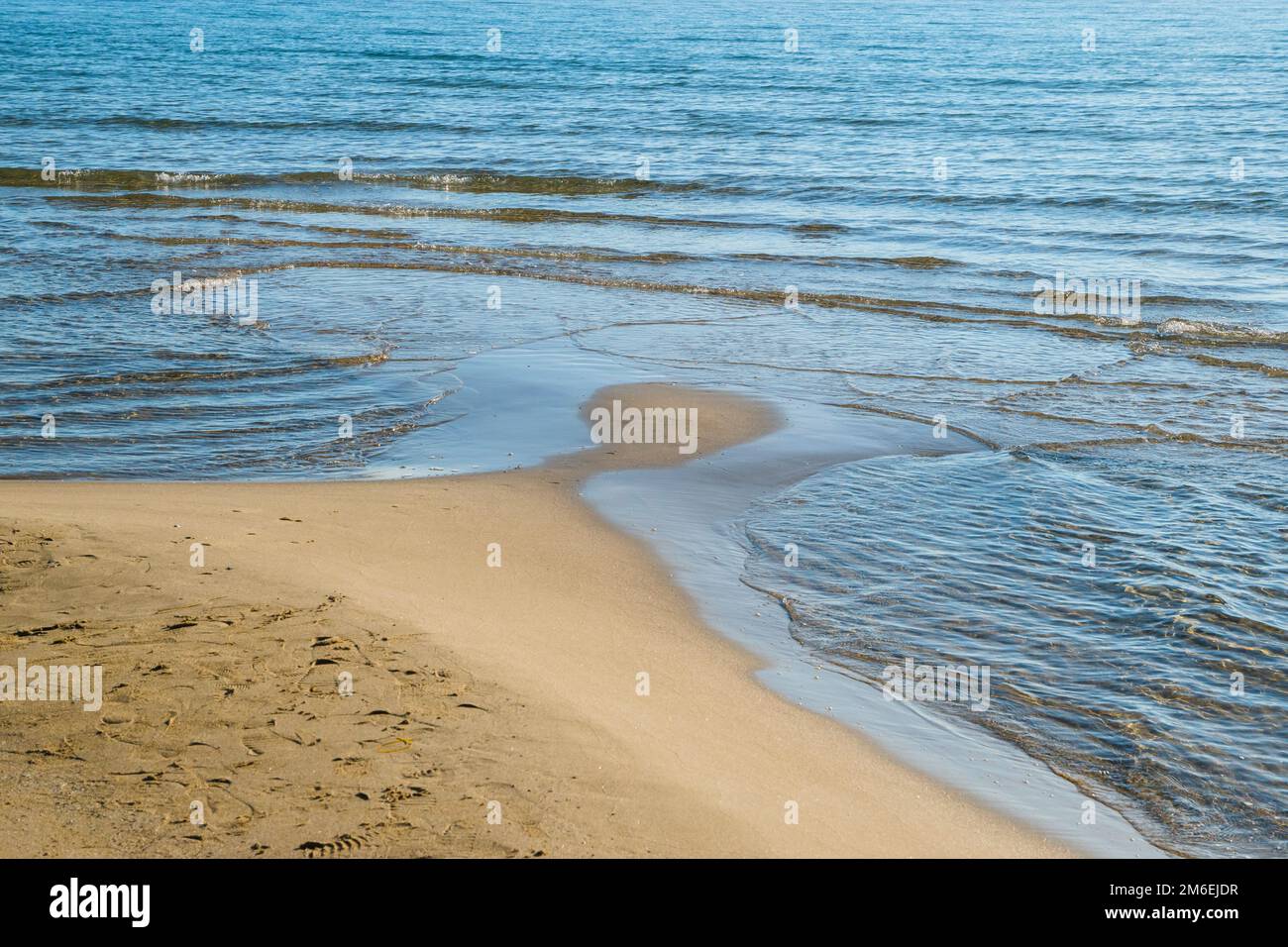 Coastal strip of the beach and calm sea waters closeup Stock Photo - Alamy