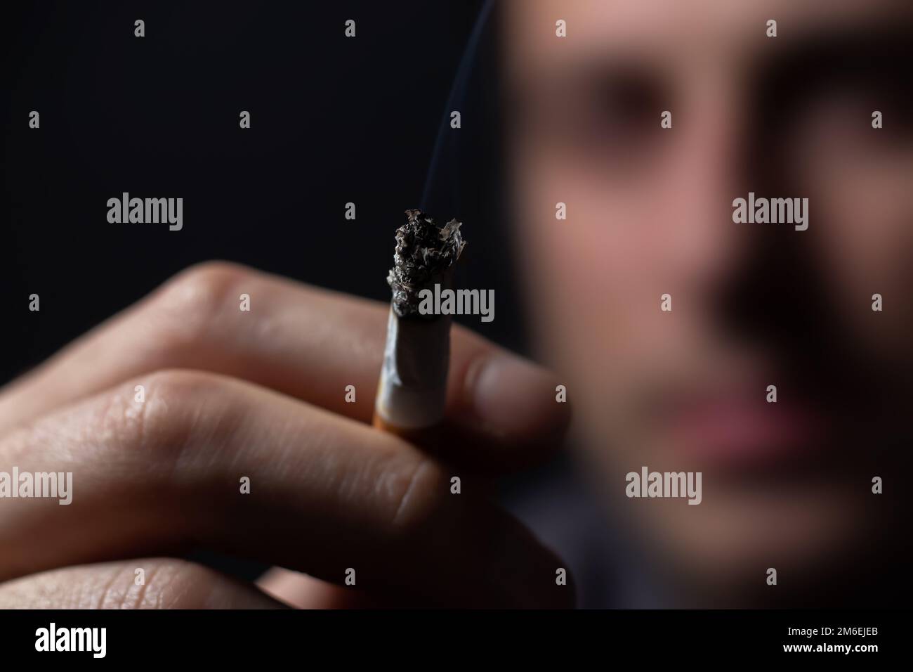 Smoking cigarette in the hand of young man close up Stock Photo - Alamy