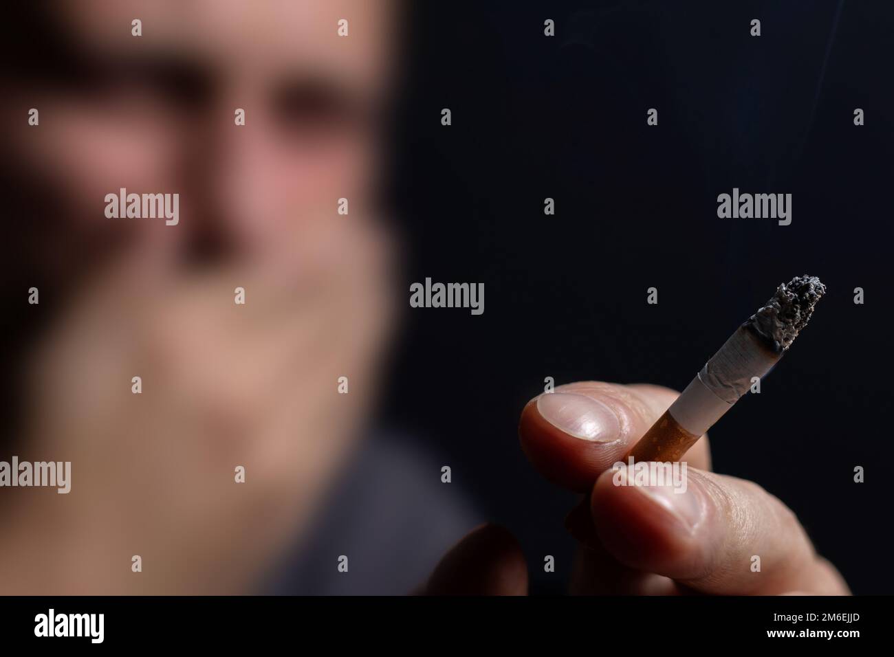 Passive smoking concept. Man is smoking cigarette and man is covering ...