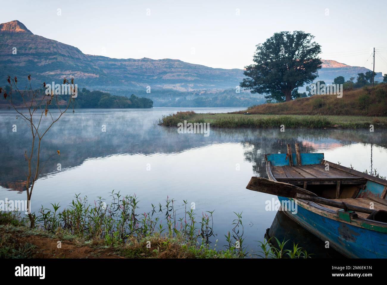 Beautiful landscape with a boat of a lake, hills, and valleys at Arthur Lake in Bhandardara in ...