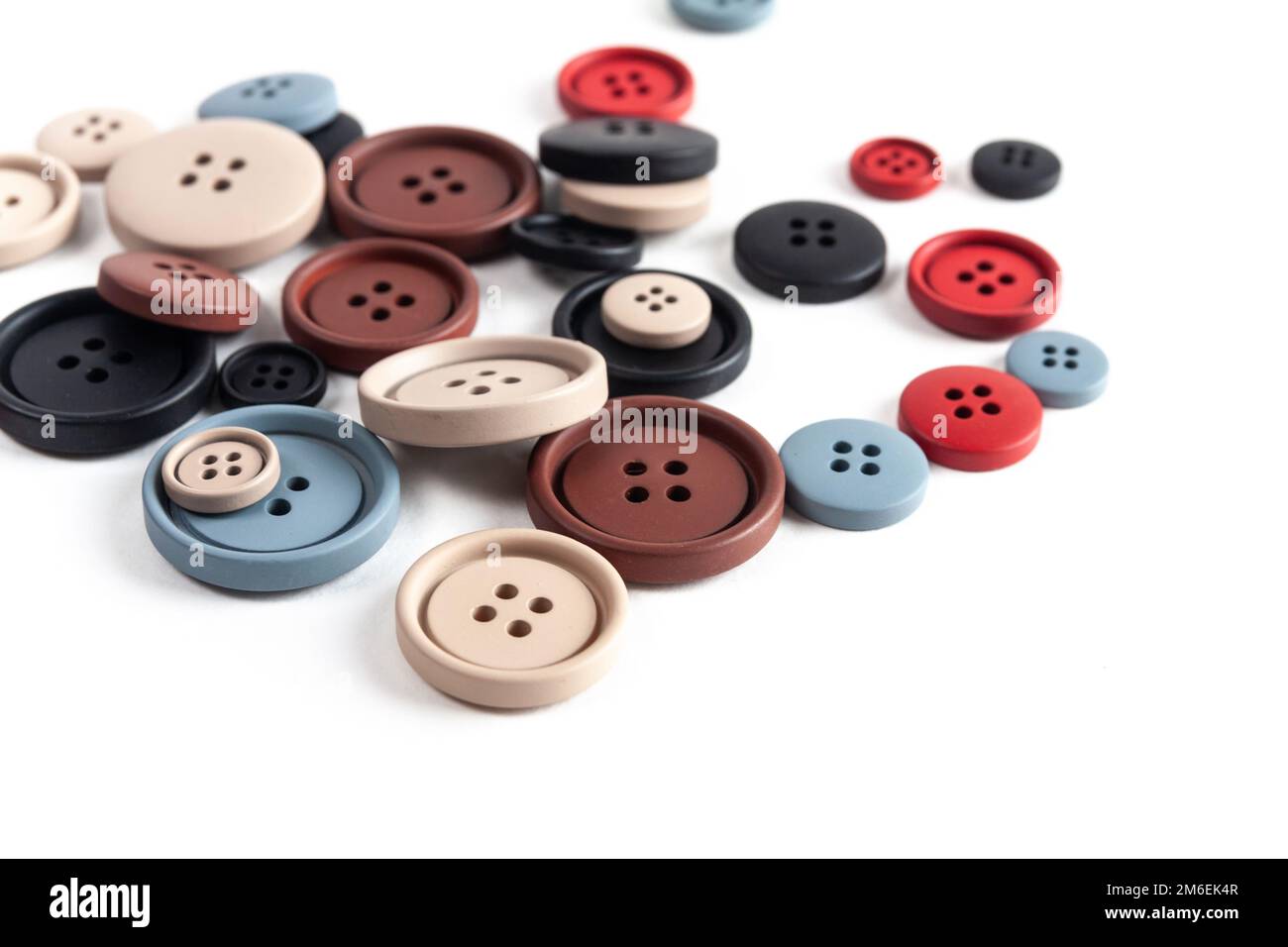 Pile of color plastic matte buttons on white, beautiful needlework ...