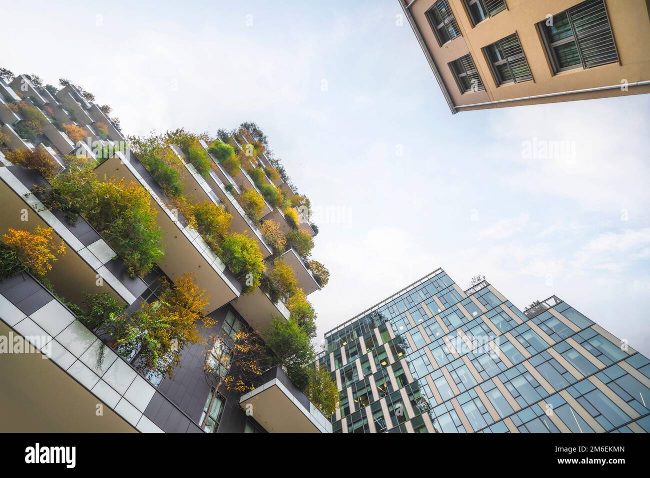 Cityscape with tall buildings covered with green plants and small trees ...