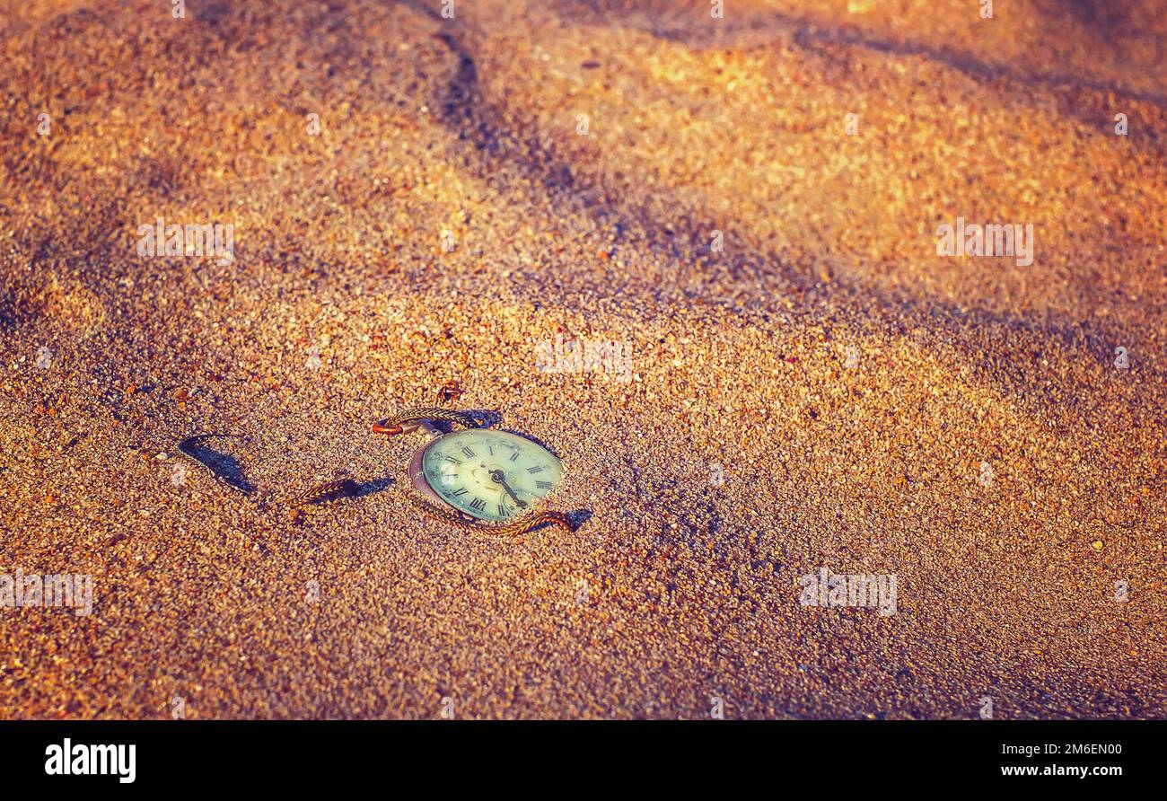 Antique rotten pocket watch buried partial in the sand Stock Photo - Alamy