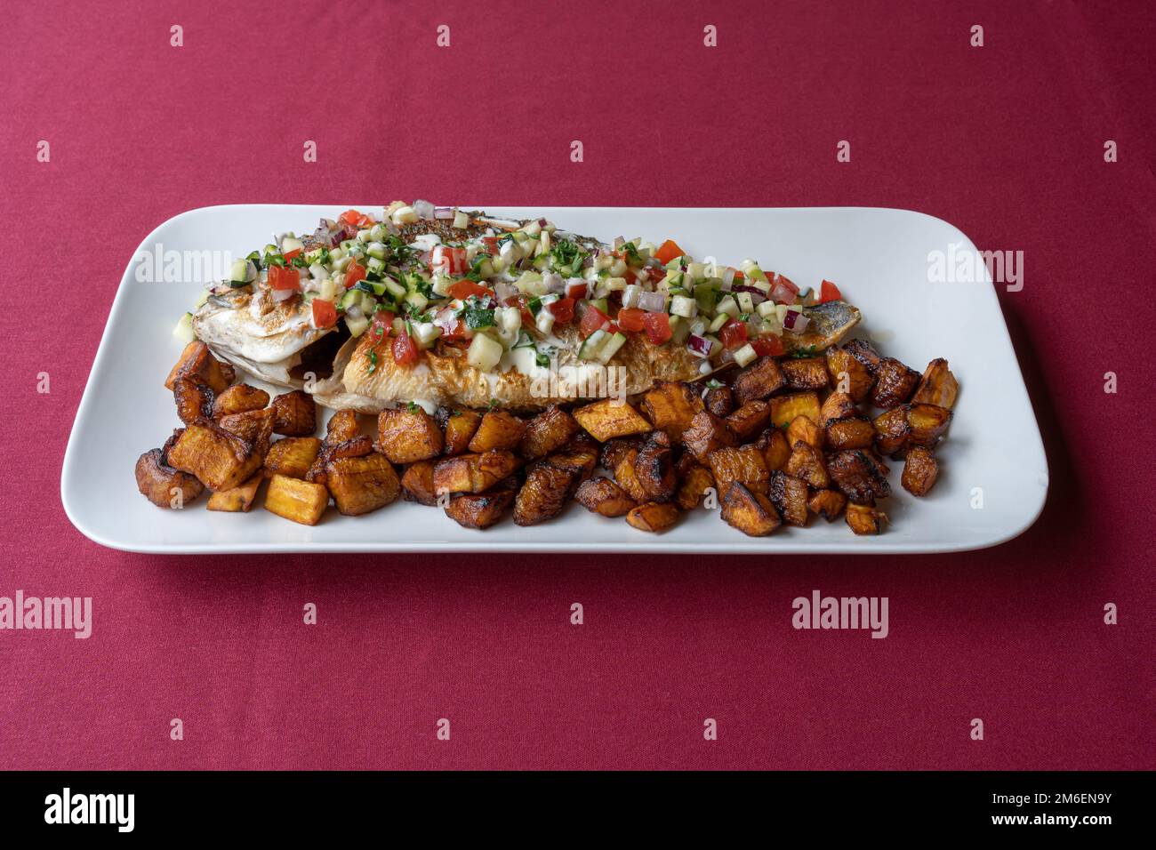 African dishe culinary Still Life. Grilled fish with fried plantain ...