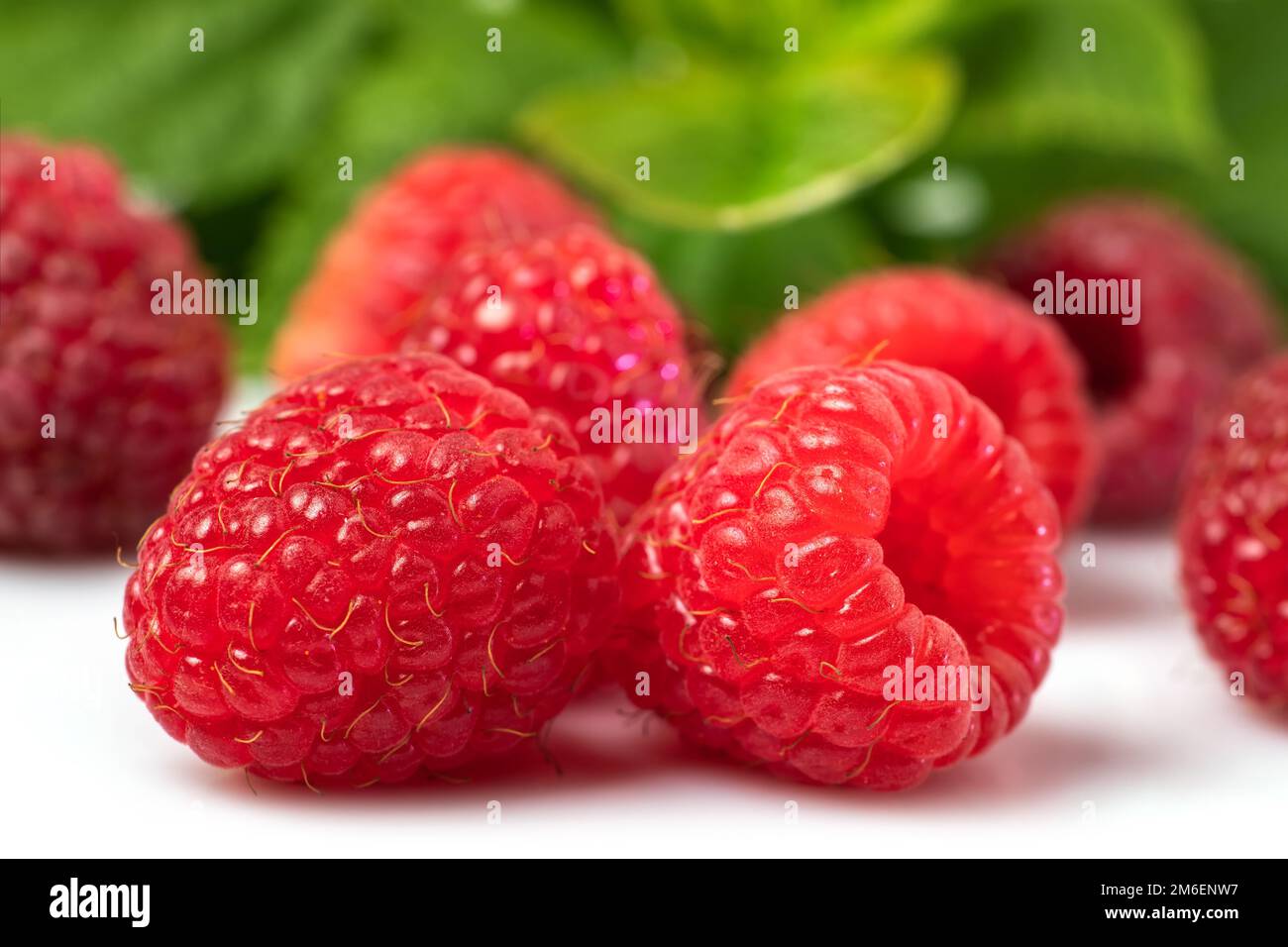 Isolated berries. Pile of raspberry fruits with leaves isolated on ...