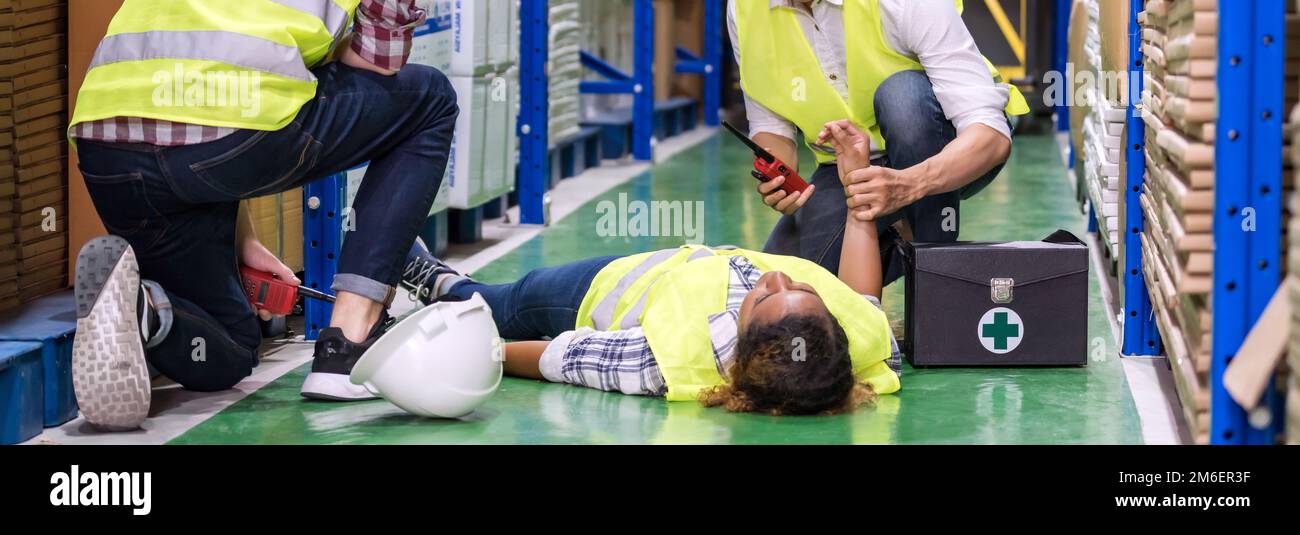 Warehouse worker frist aid after accident panoramic Stock Photo - Alamy