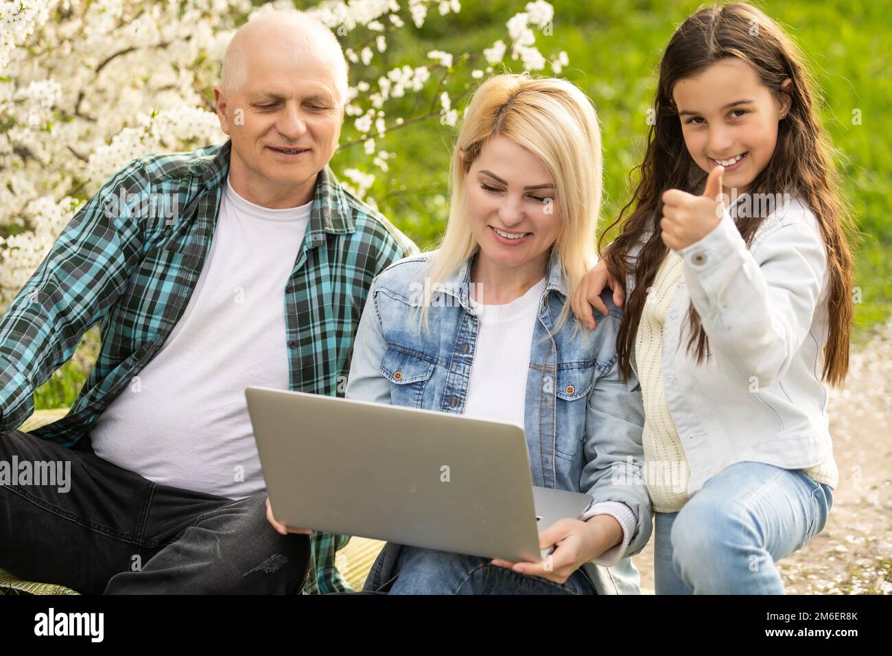 Three generation family sitting outside in spring nature Stock Photo ...
