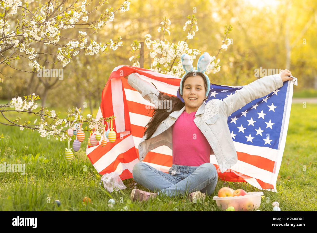 Girl kid in rabbit bunny ears on head with colored eggs and american ...