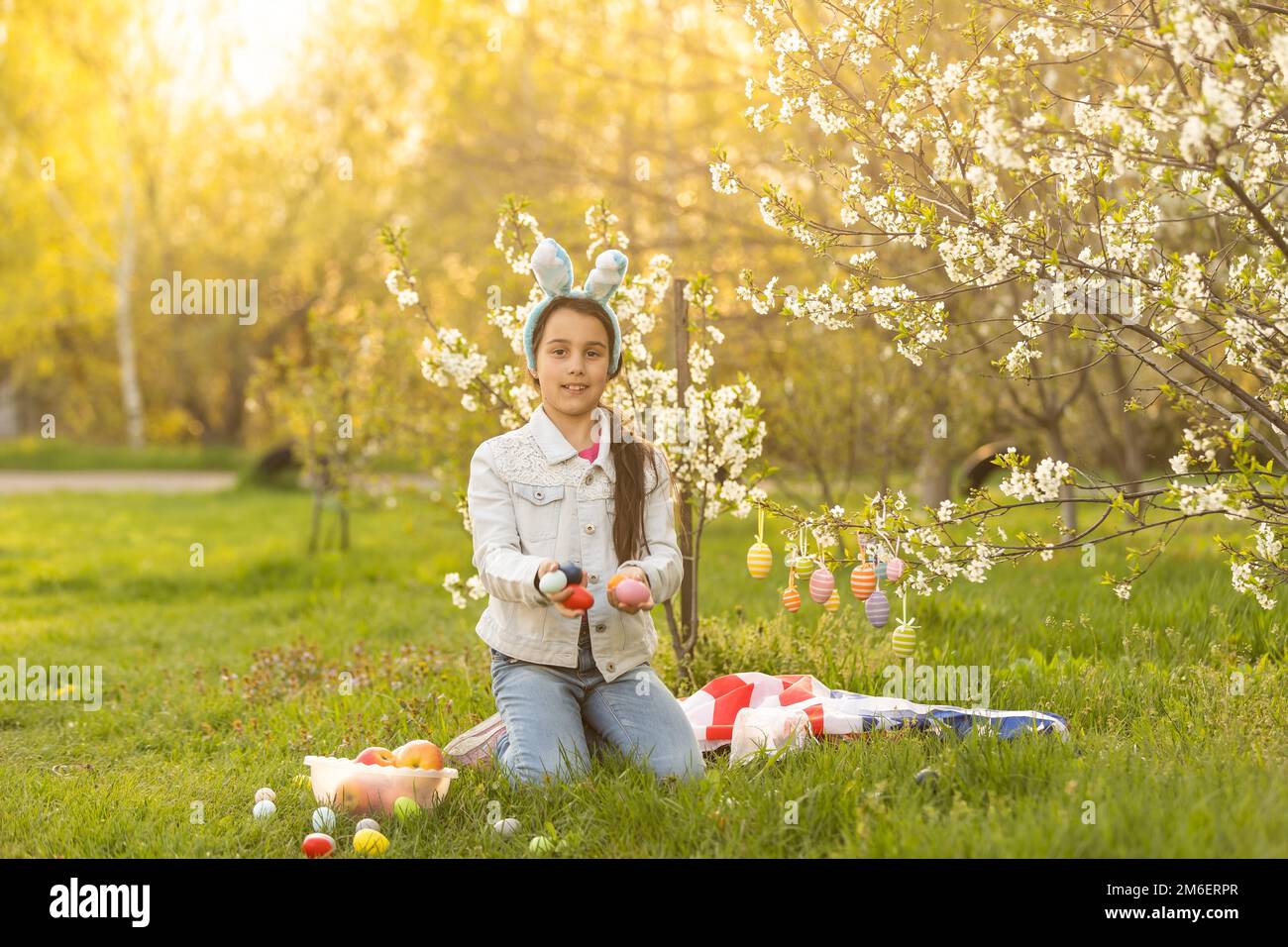 Girl kid in rabbit bunny ears on head with colored eggs and american ...