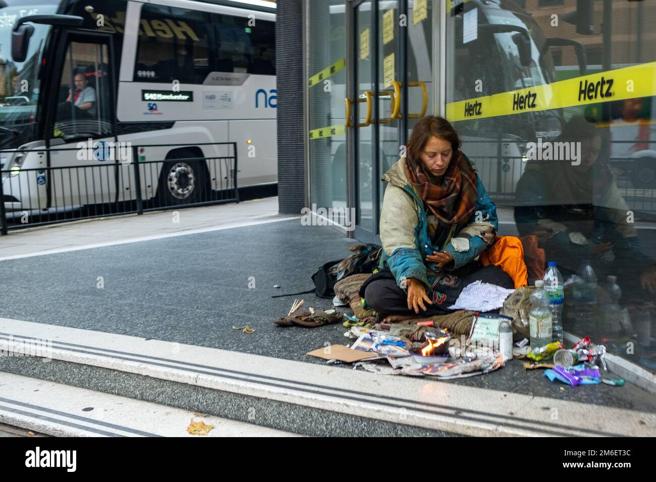 London- November 2022: A homeless woman warming her hands on a make ...