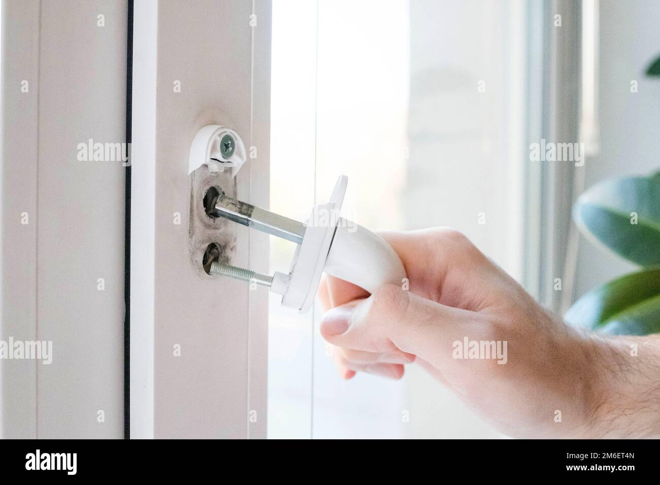 The window handle cracked. The man holds it in his hand, the iron pins ...
