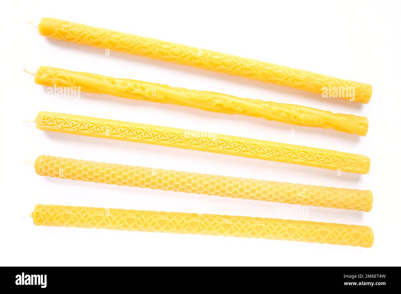 Large yellow candles with different cut patterns on white Stock Photo ...
