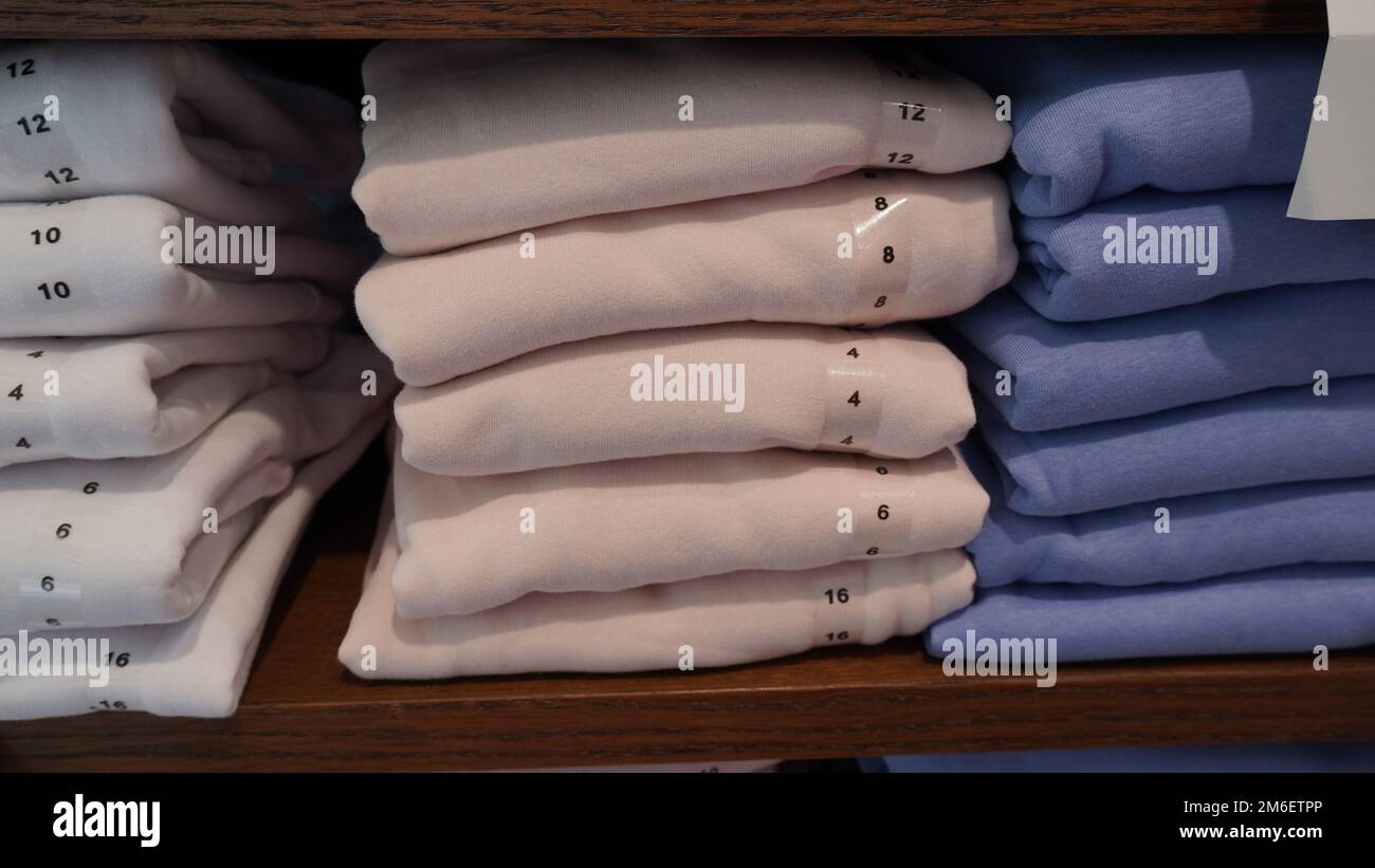 Stack of cloth different colors and sizes on the shelves in a clothes ...