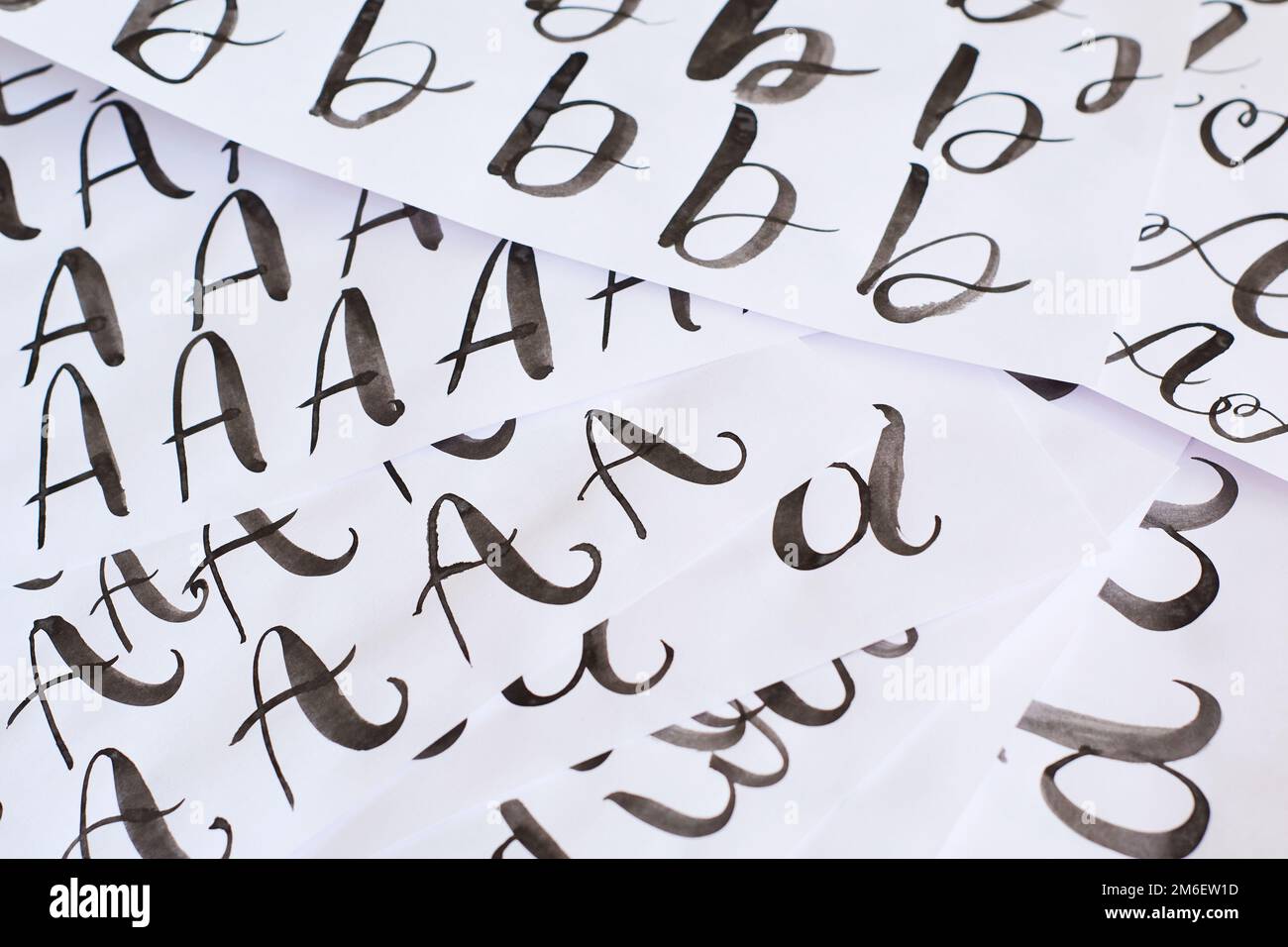 Several white sheets with calligraphic exercises. Calligraphy practice ...