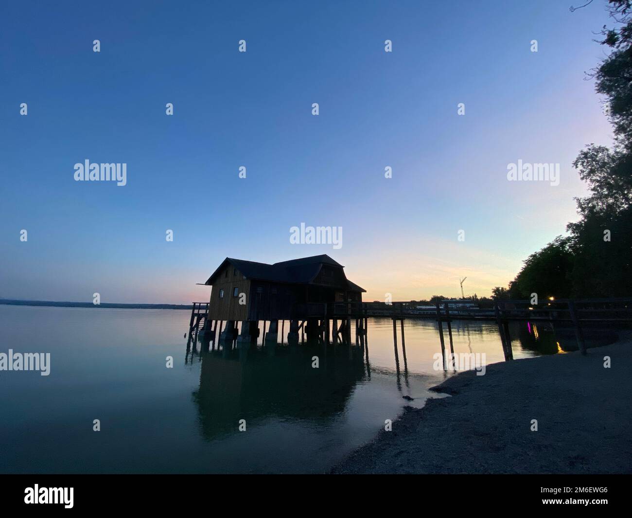 A beautiful shot of an overwater bungalow on stilts, during the blue ...