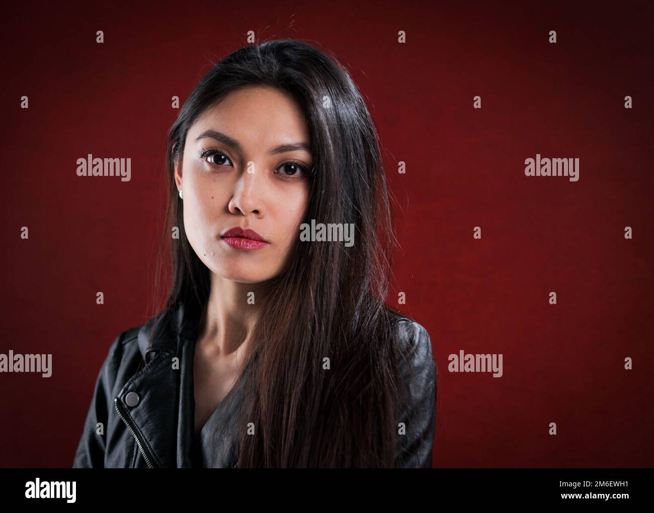Young self-confident woman against a red background Stock Photo - Alamy