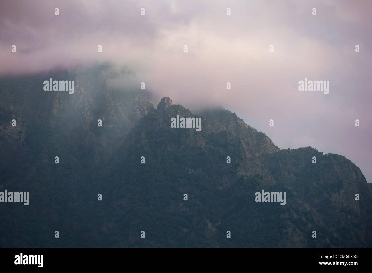 Dark atmospheric surreal landscape with a dark rocky mountain peak in ...
