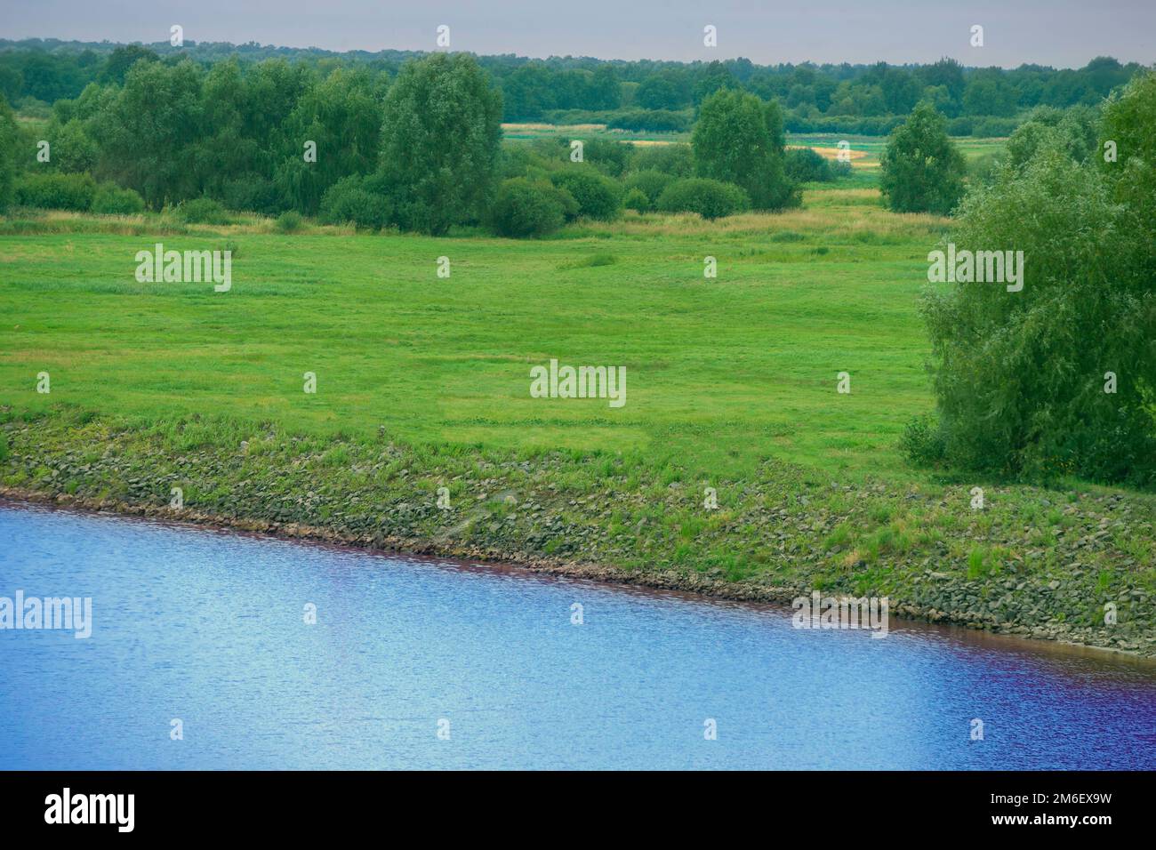 The blue water of the river and the green field of the plains Stock ...