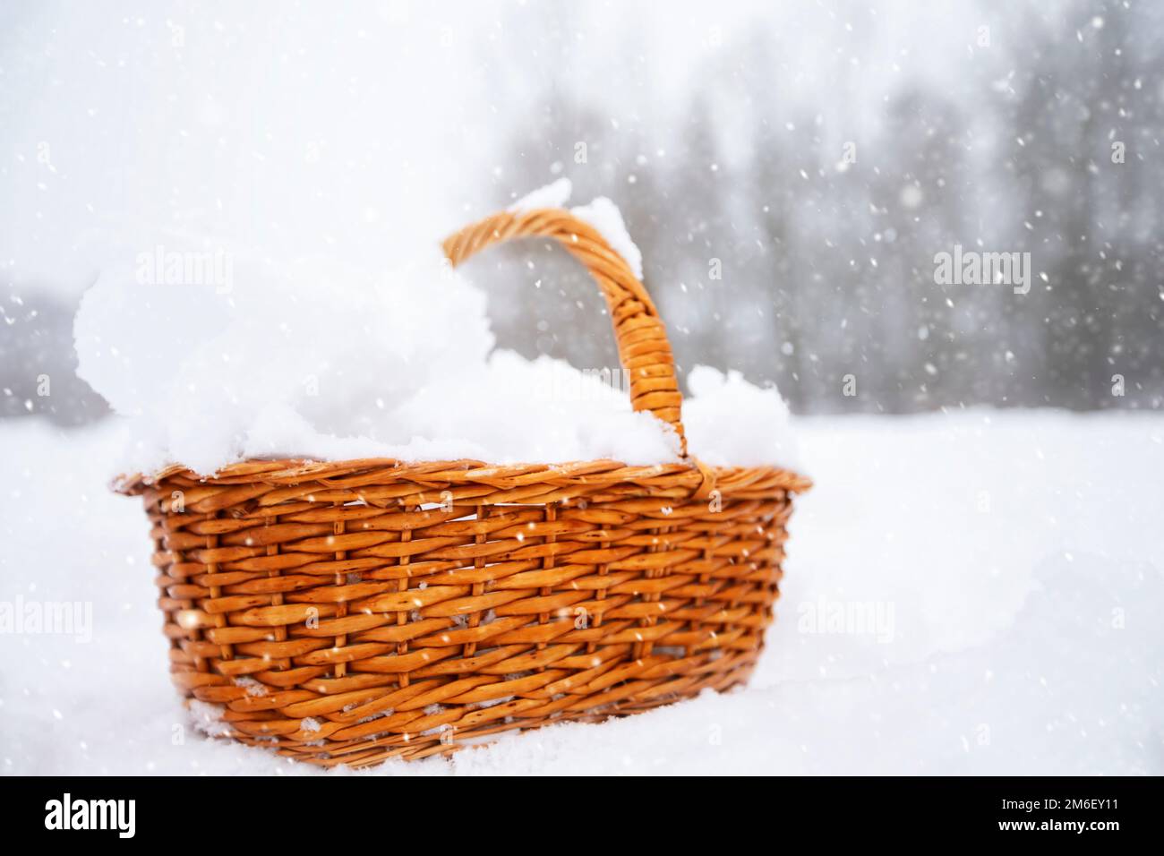 Wicker basket filled with snow on a Christmas background. Snow in a ...