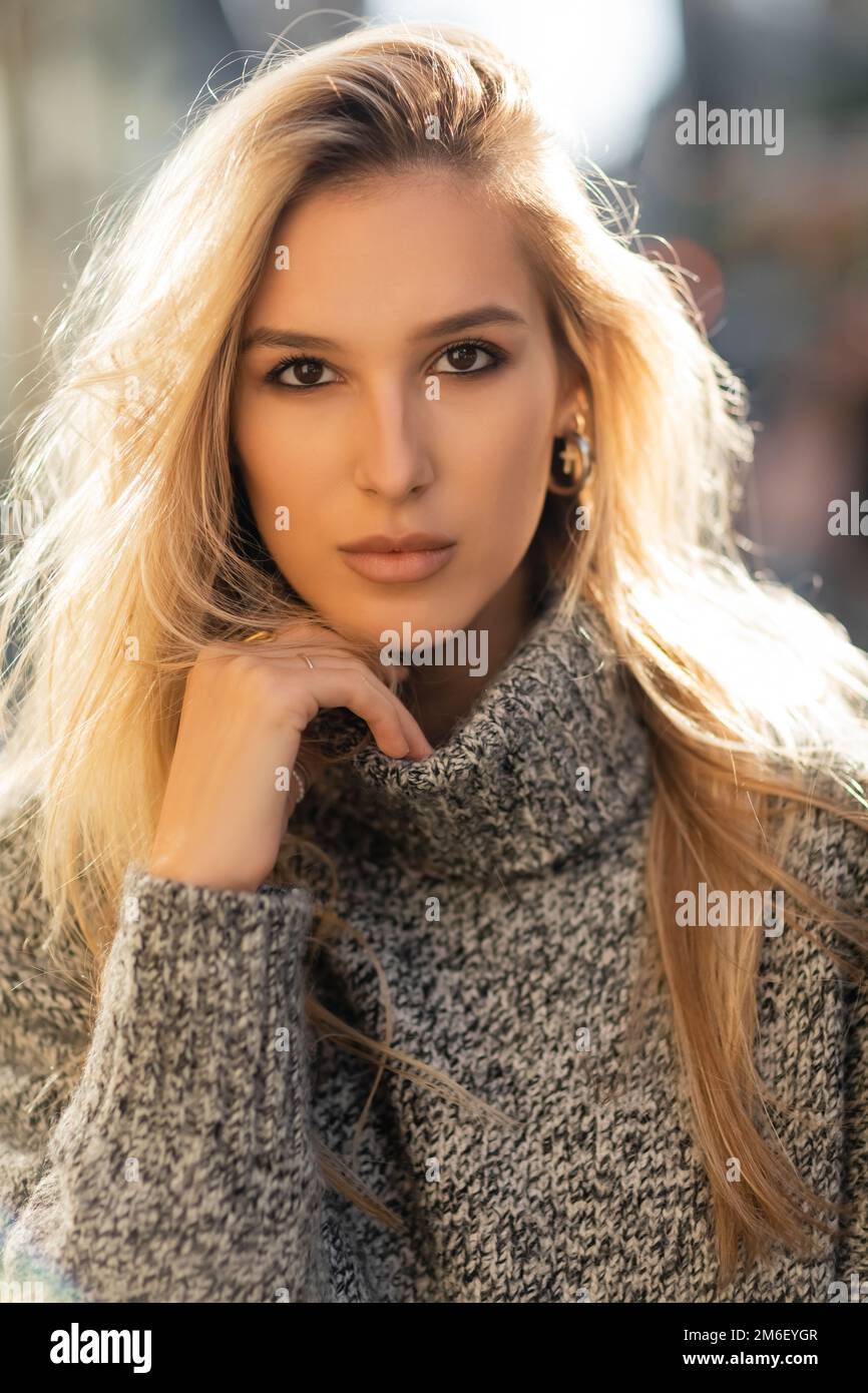 portrait of pretty young woman in sweater looking at camera in New York ...