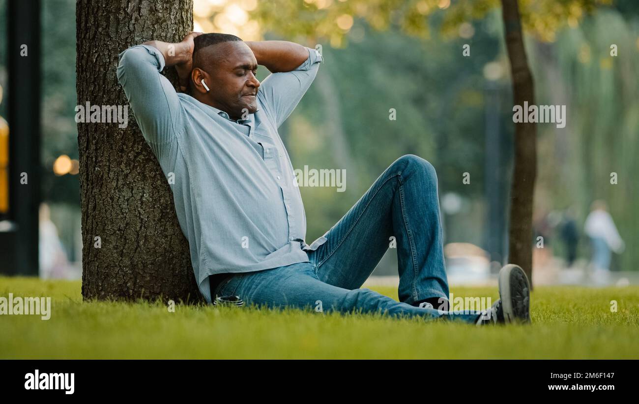 Calm relaxed resting middle-aged male listening music with earphones ...