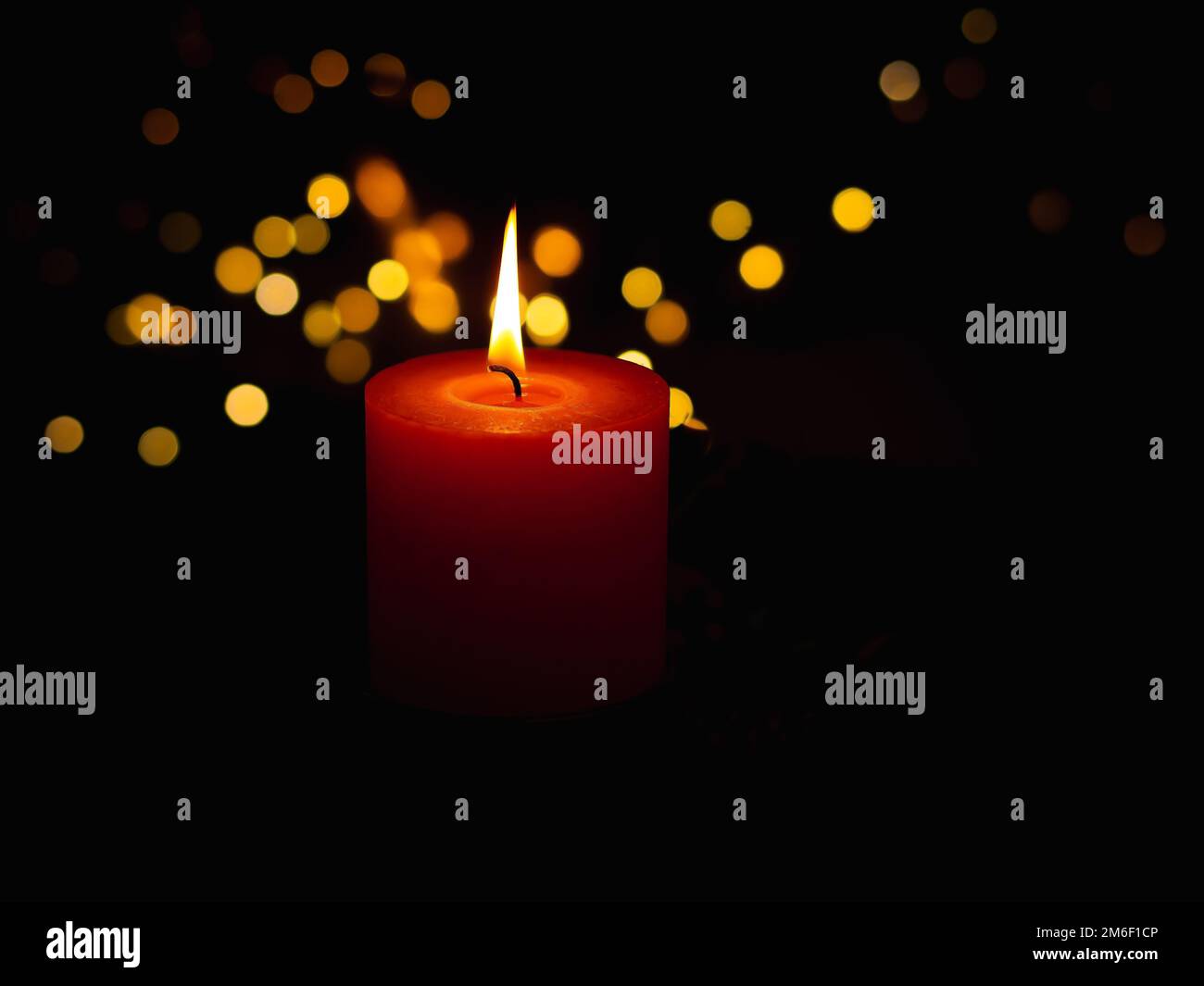 A closeup shot of a burning red candle on a dark bokeh background Stock ...