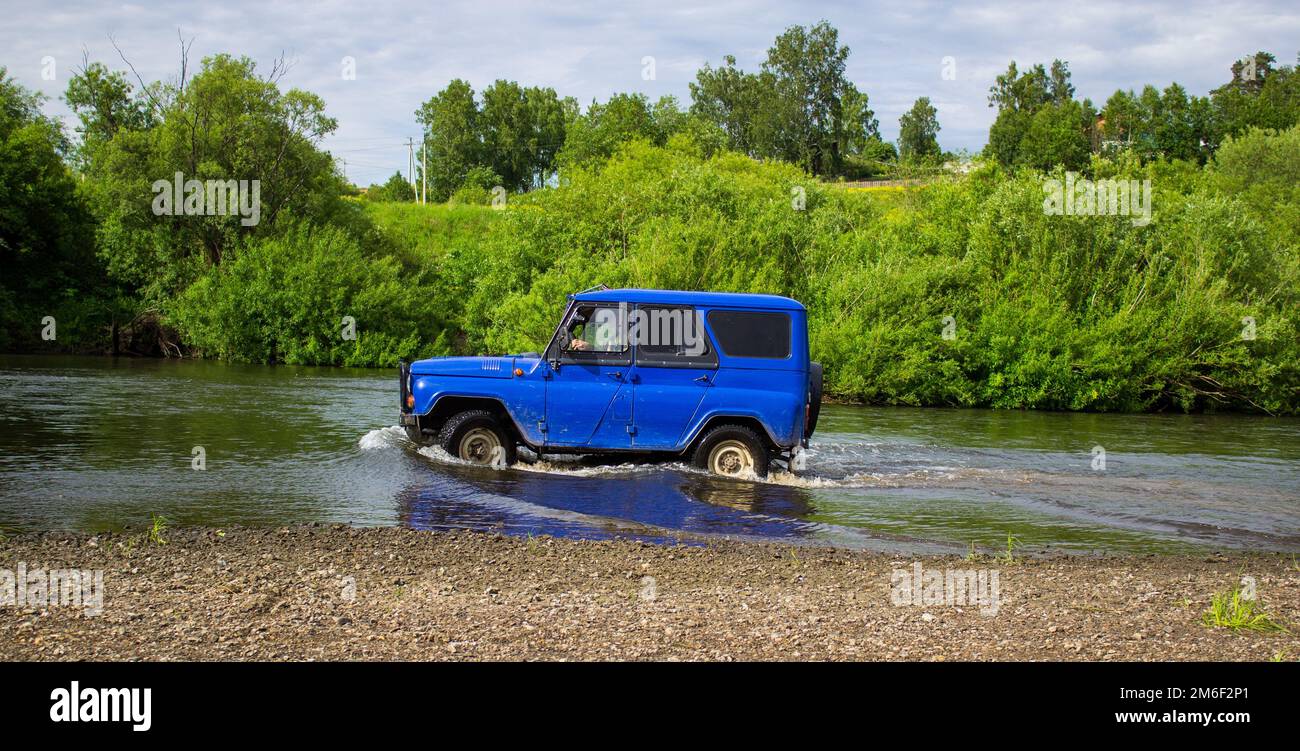 Car SUV rides on the river. SUV blue color Stock Photo - Alamy
