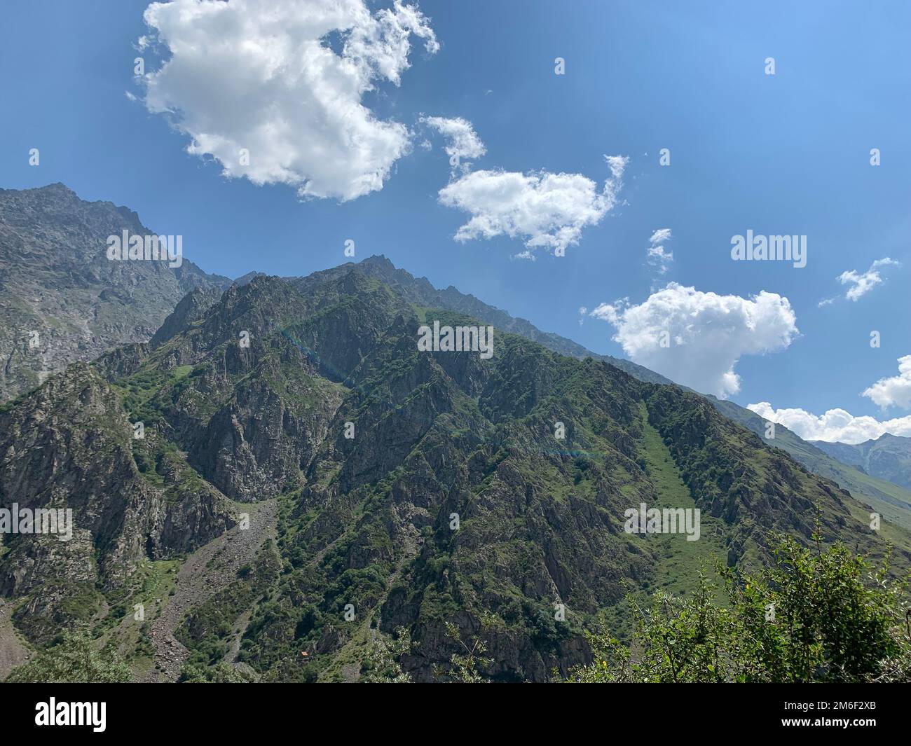 A scenic view of green mountains in Kazbegi, Georgia near the Gergeti ...