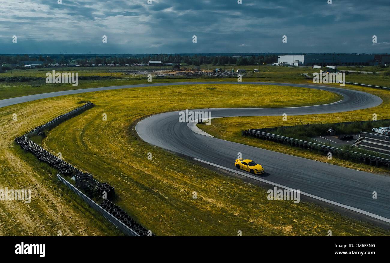 Yellow car on the race track. section of the race track Stock Photo - Alamy
