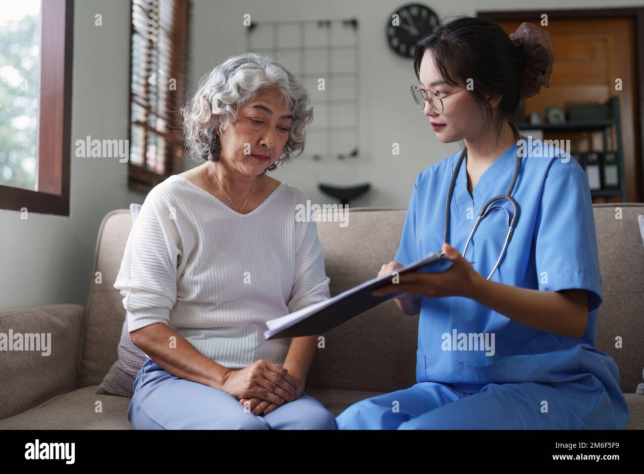 Asian youthful nurse caring for patients or the elderly at home ...